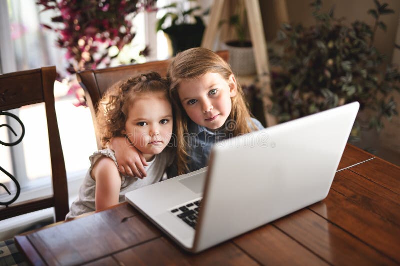 Two Girls Using Laptop on the Kitchen Table Stock Image - Image of ...