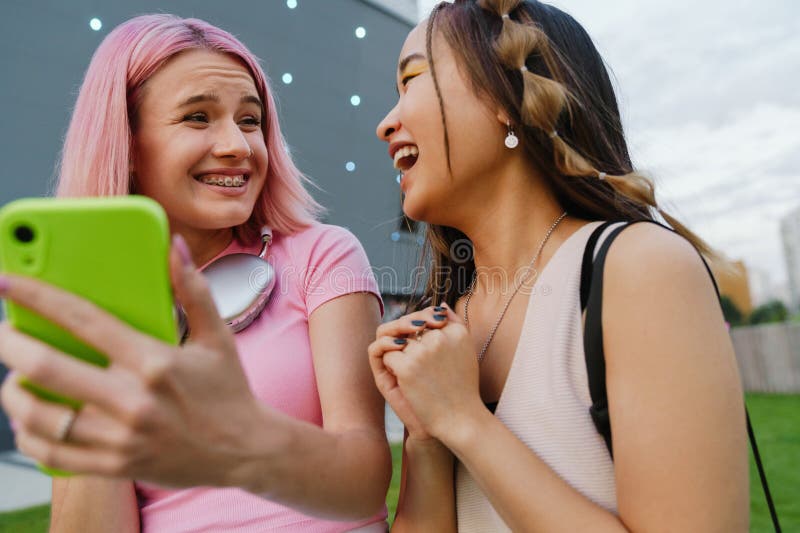 Two Girls Using Smartphone while Standing Outdoors Stock Photo - Image ...