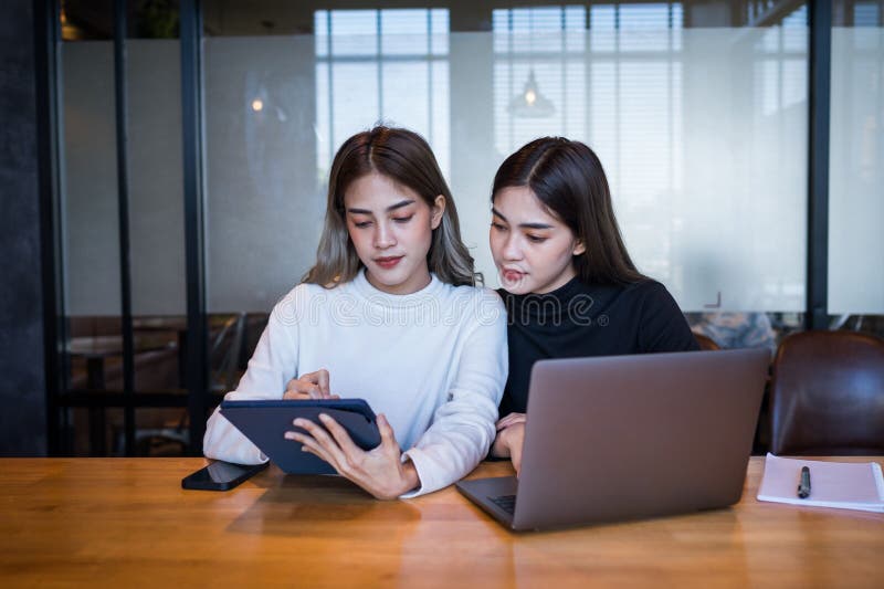 Two Girls Using Their Tablet and Computer in a Meeting Room Stock Photo ...