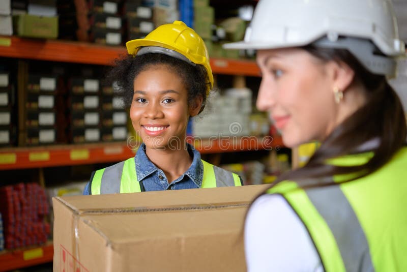 Two Girls Warehouse Workers Help Each Other Lift Heavy Boxes Stock ...