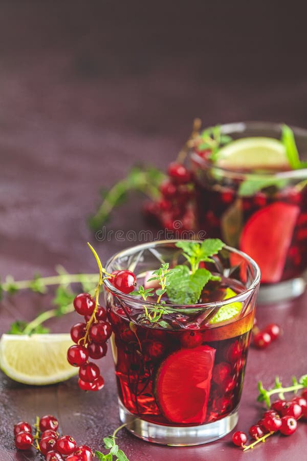 Two Glasses of Cold Red Cocktail with Currant, Lime, Mint, Thyme and ...