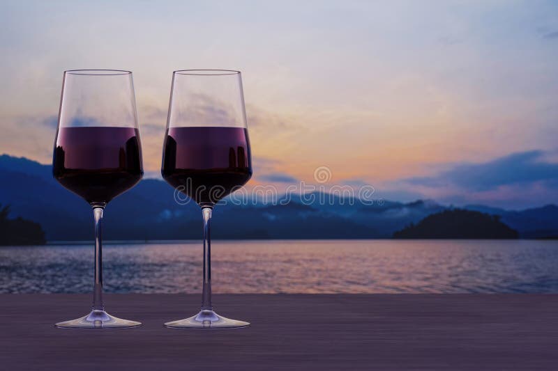 Two Glasses of Red Wine with View of Sunset Over Lake and Mountains ...