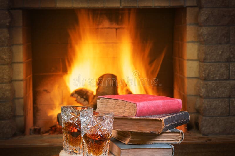 Two Glasses of Whiskey and Old Books on a Background of a Burning ...