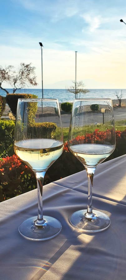 Two Glasses of White Wine on a Table in a Cafe during Sunset Stock ...