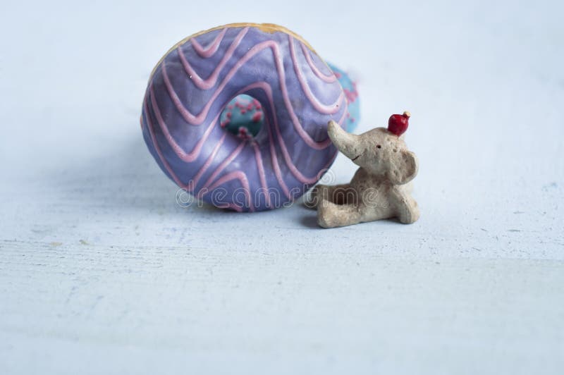Two Glazed Donuts with an Elephant Figurine, Stock Image - Image of ...