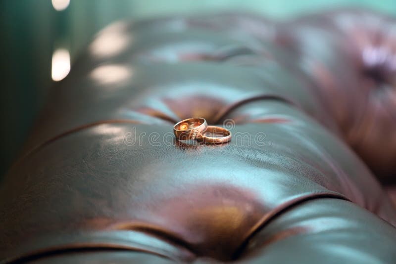 Two Gold Rings on the Leather Sofa Stock Photo - Image of couple ...