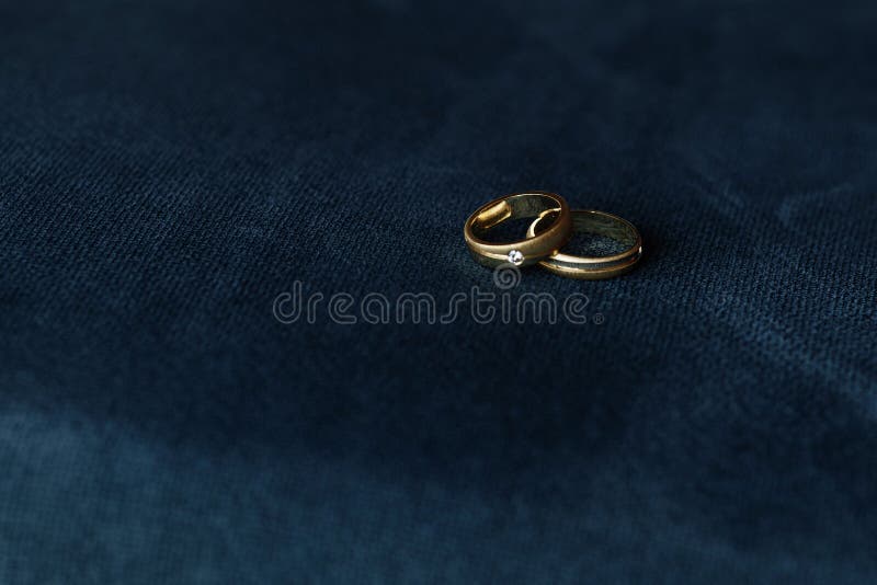 Two Gold Wedding Rings are on a Blue Cloth Stock Image - Image of ...