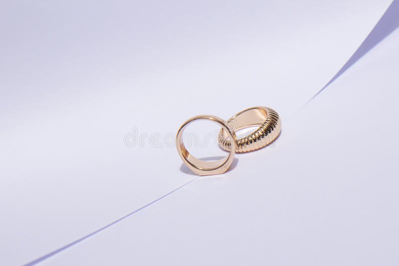 Two Gold Wedding Rings on White Background with Contrasting Shadows ...