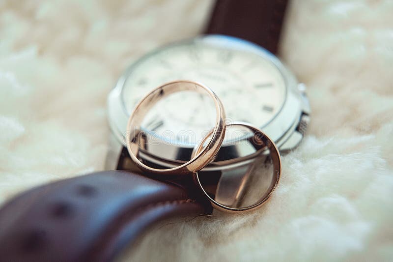 Two Golden Wedding Rings on Watch with Brown Strap Stock Image - Image ...