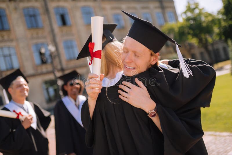 Two Graduates Hugging in Front of Their University. Stock Image - Image ...