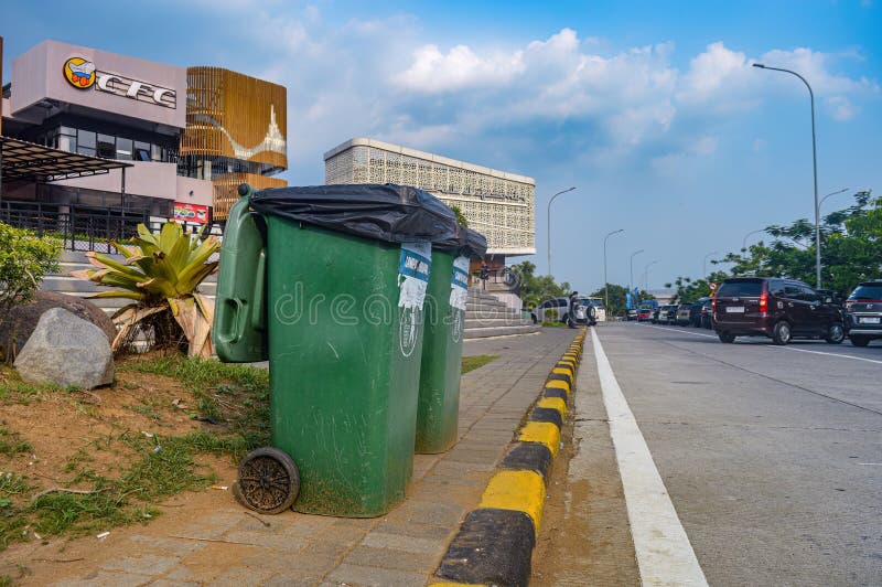 Two Green Trash Cans on the Side of the Parking Lot in Front of the ...