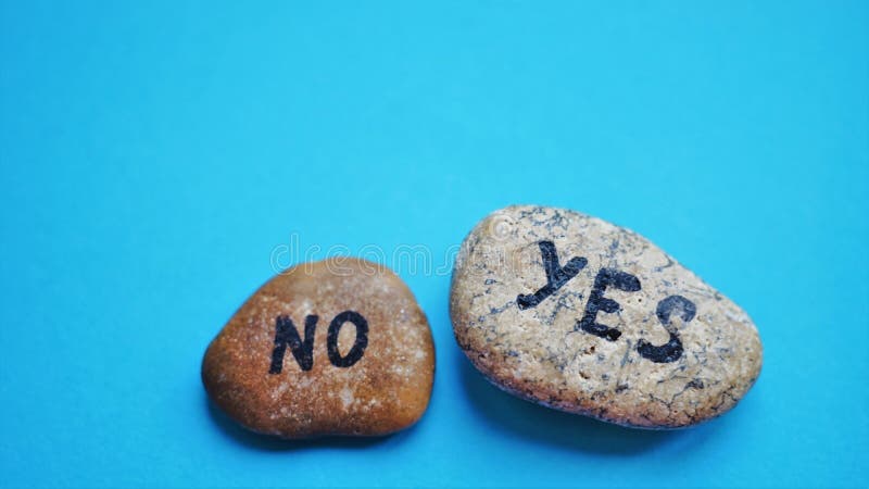 Two Grey Pebbles with the Text Yes and No on a Blue Table Stock Image ...