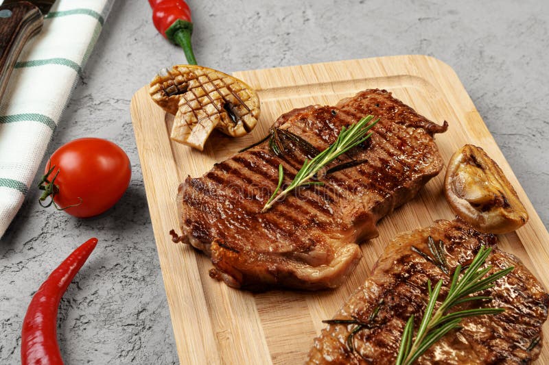 Two Grilled Beef Steaks on Wooden Board Stock Photo - Image of steak ...