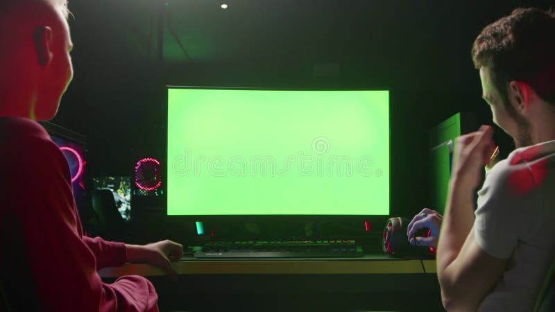 Two Guys are Sitting at a Computer and Looking at a Green Screen Stock ...