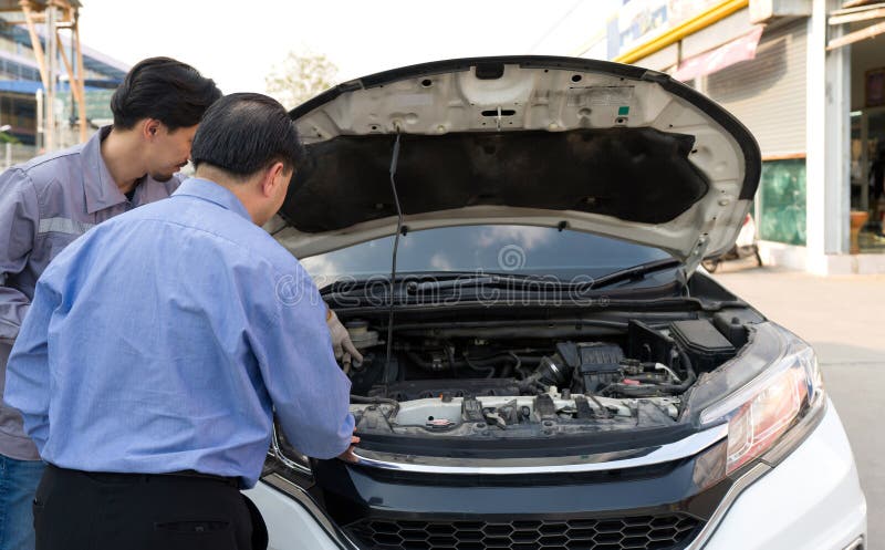 Two Guys are Standing by a Car with the Hood Open, Staring at the ...