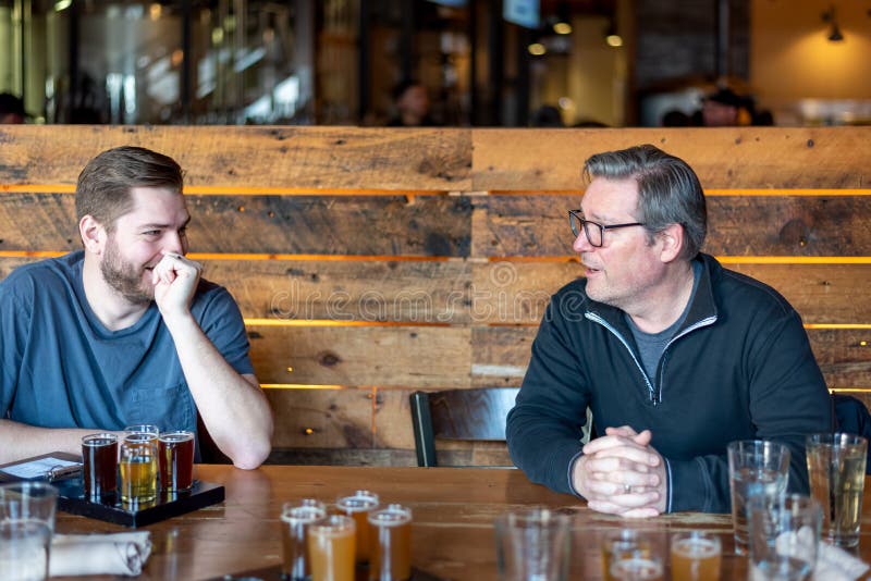 Two Guys Talking and Laughing while Tasting Beer Samples Stock Image ...