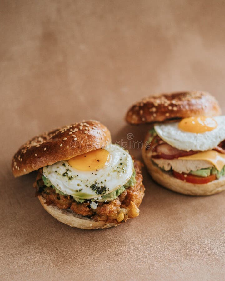 Two Halved Bagel Breakfast Sandwiches with Eggs, Cheese, and Spinach on ...