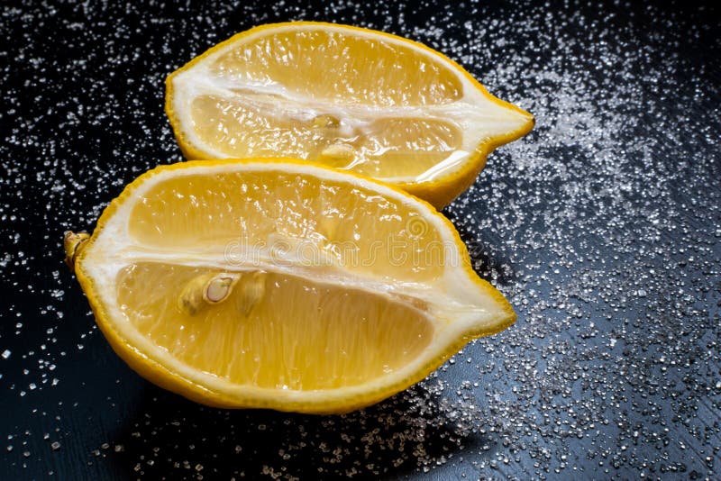 Two Halves Lemon on a Black Table with Sugar Stock Photo - Image of ...