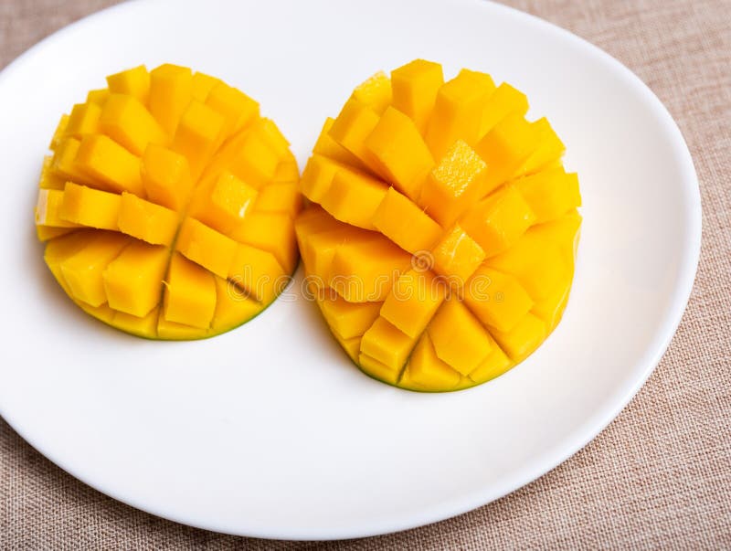 Two Halves of Ripe Yellow Mango Cut into Cubes Lie on White Round Plate ...