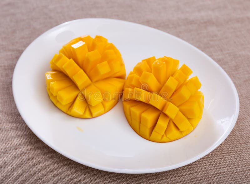 Two Halves of Ripe Yellow Mango Cut into Cubes Lie on White Round Plate ...
