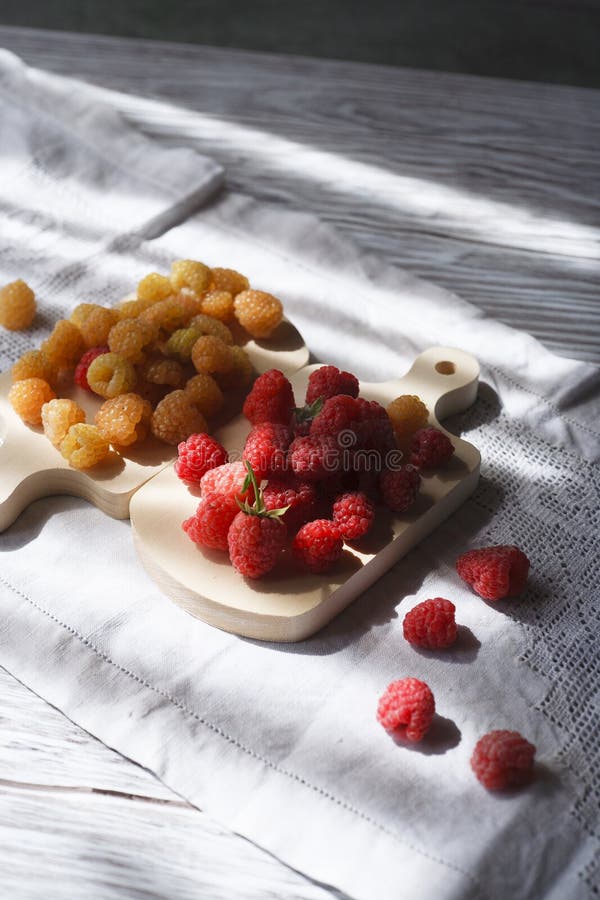 Two Handfuls of Fresh Red and Yellow Raspberry on White Wooden Kitchen ...