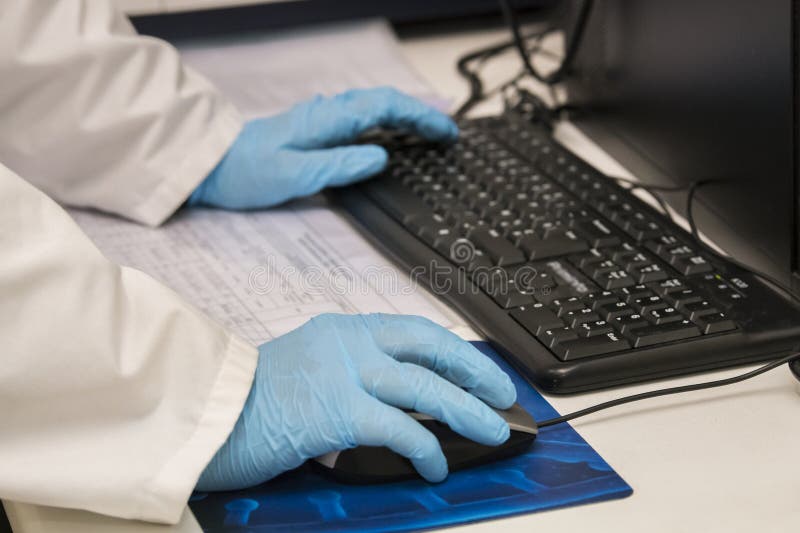 Two Hands in Blue Nitril Gloves Using a Computer Mouse on a Blue ...
