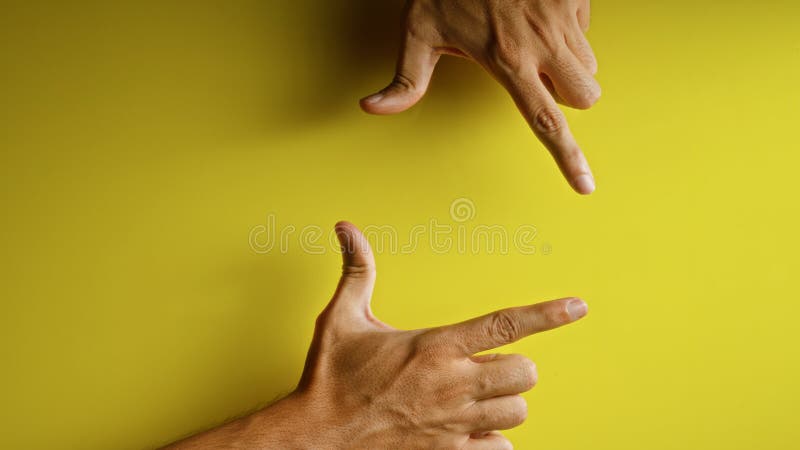 Two Hands with Fingers Forming a Frame Against a Bright Yellow ...