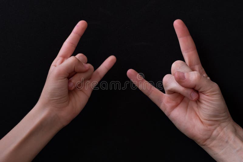 Two Hands Making the Sign of the Horns Together with a Black Background ...
