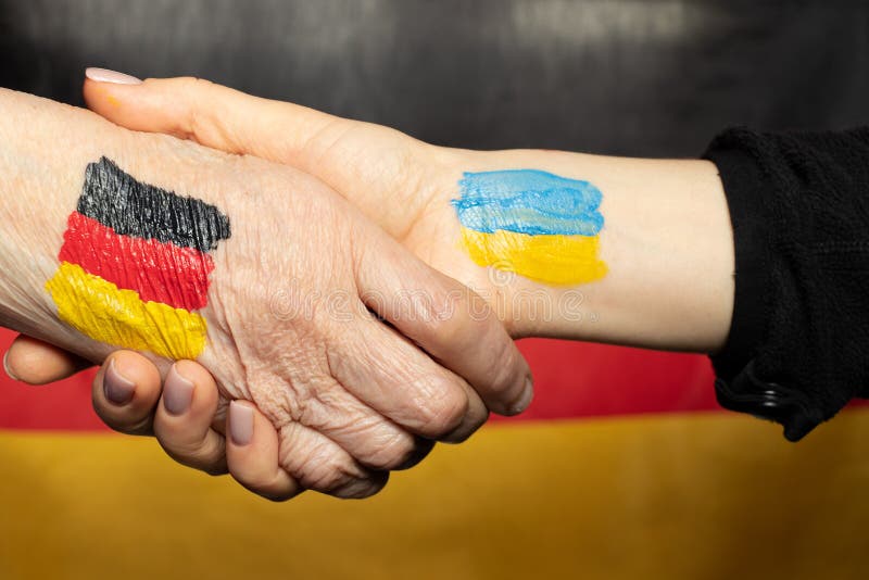 Two Hands One with a Drawn Flag of Germany and the Second with a Drawn ...