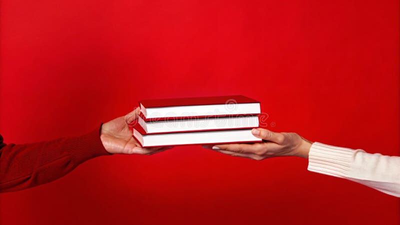 Hands Exchanging Three Red Books Against a Bright Red Background Stock ...