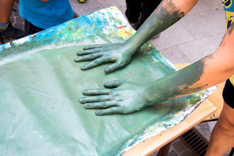 Two Hands Smudging Green Acrylic Paint on a Piece of White Paper Stock ...