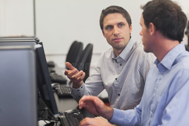 Two Handsome Men Talking while Sitting in Computer Class Stock Photo ...