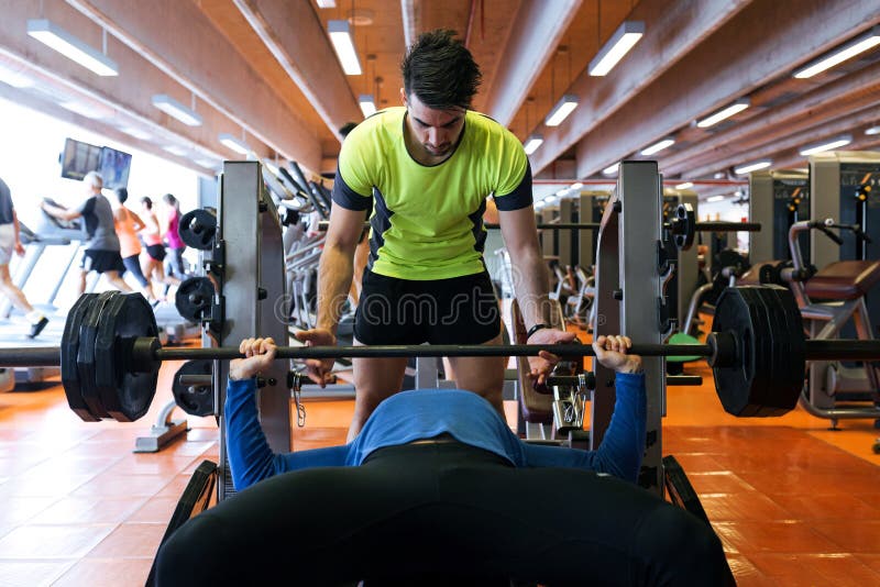 Two Handsome Young Men Doing Muscular Exercise in Gym. Stock Photo ...