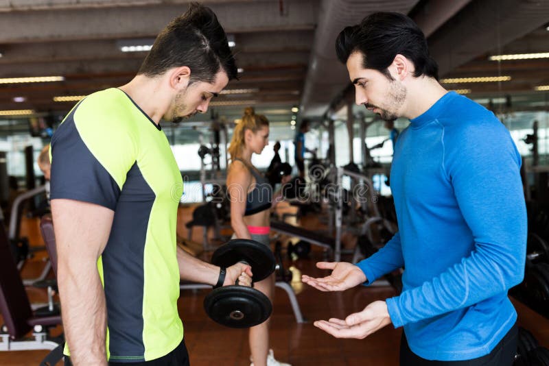 Two Handsome Young Men Doing Muscular Exercise in Gym. Stock Photo ...