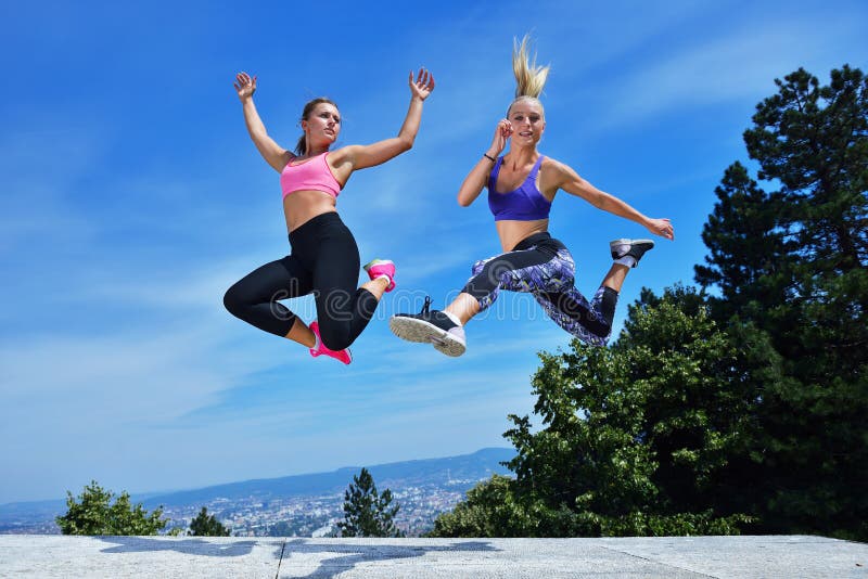 Two Happiness Young Women Jumping Over Blue Sky Stock Photo - Image of ...
