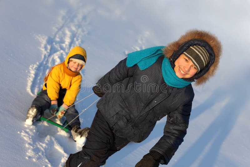 Two happy boys on sled stock image. Image of child, actions - 43834075