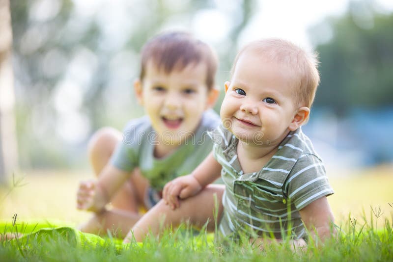 Two Happy Brothers Playing on Grass in Park. Stock Photo - Image of ...