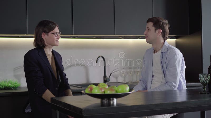 Two Happy Caucasian Gay Men Talking In The Kitchen And Smiling