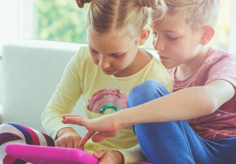 Two Happy Children Playing with Tablet on the Sofa Stock Image - Image ...