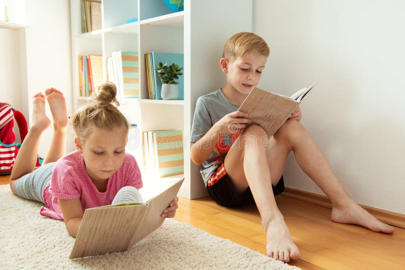 Happy Children Reading Books on the Floor at the School Library Stock ...