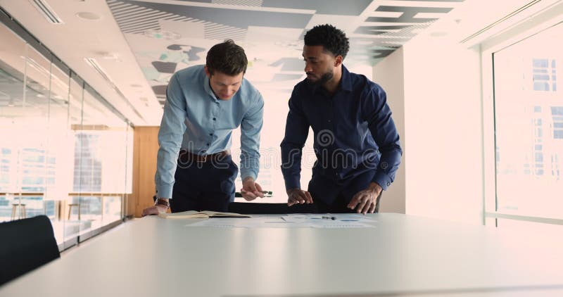 Two Diverse Workers Discuss Business Process Documents and Strategy ...