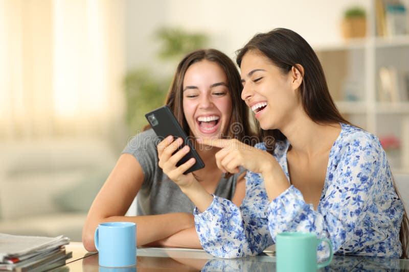 Two Happy Friends Laughing Checking Smart Phone at Home Stock Image ...