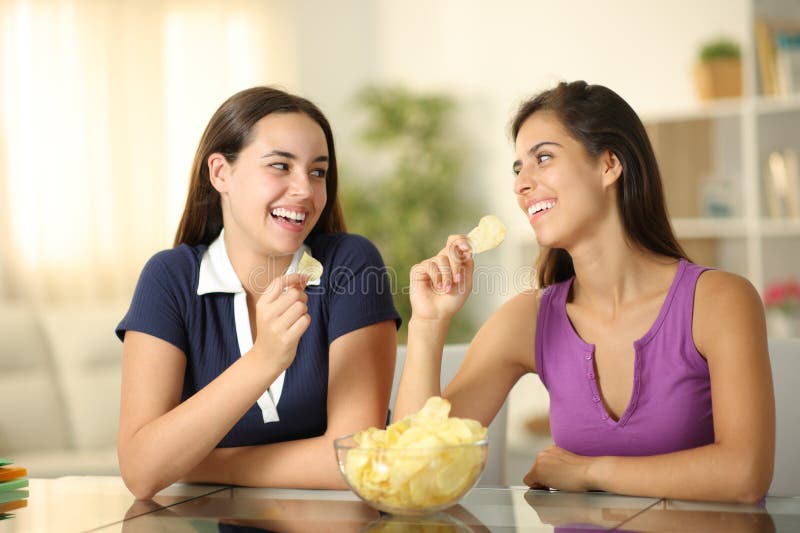 Two Happy Friends Talking Eating Potato Chips Stock Photo - Image of ...