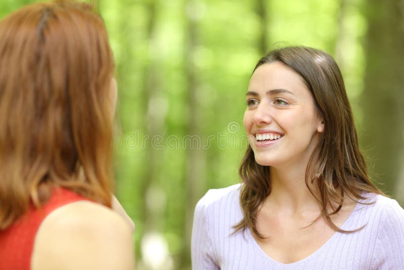 Two Happy Friends Talking in a Green Forest or Park Stock Photo - Image ...