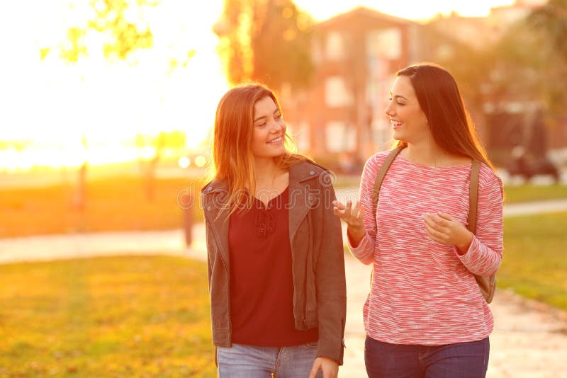Two Happy Friends Walking and Talking at Sunset Stock Image - Image of ...