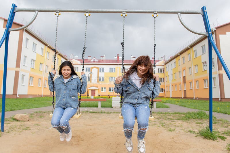 Two Happy Girls Ride a Swing Stock Photo - Image of exotic, childhood ...