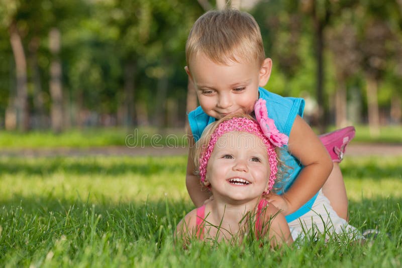 Two Happy Kids on the Grass Stock Image - Image of play, happy: 20703085