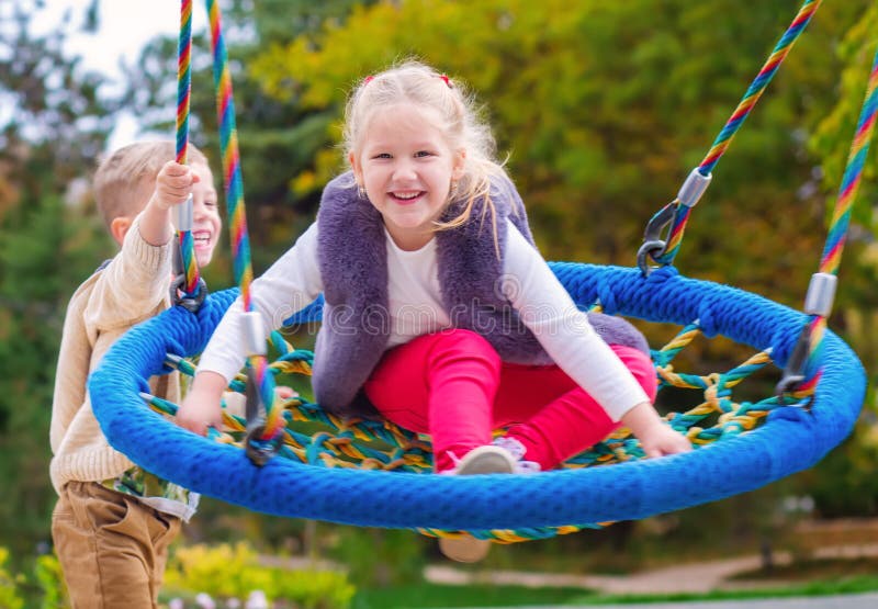 Two Happy Little Children Having Fun on a Swing Stock Photo - Image of ...