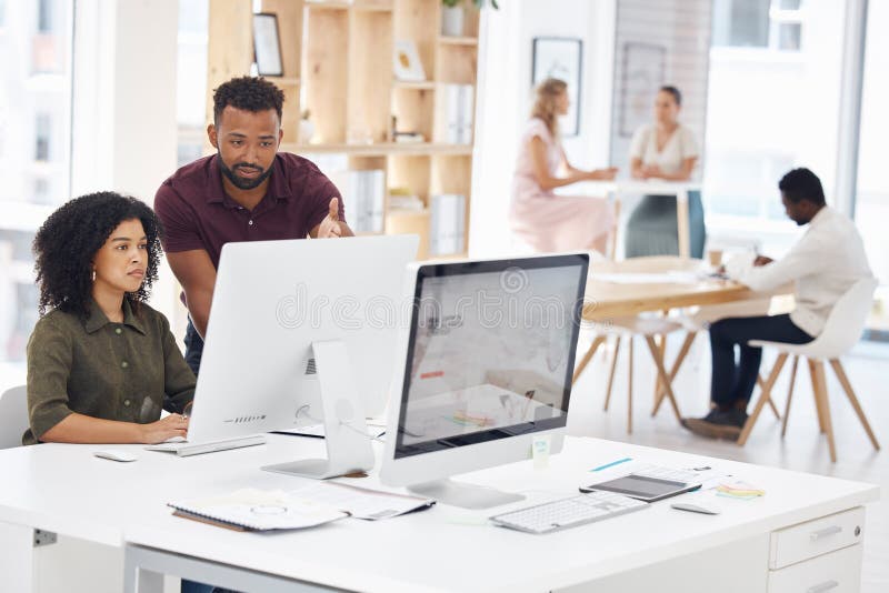 Two Happy Mixed Race Businesspeople Working on a Computer in an Office ...