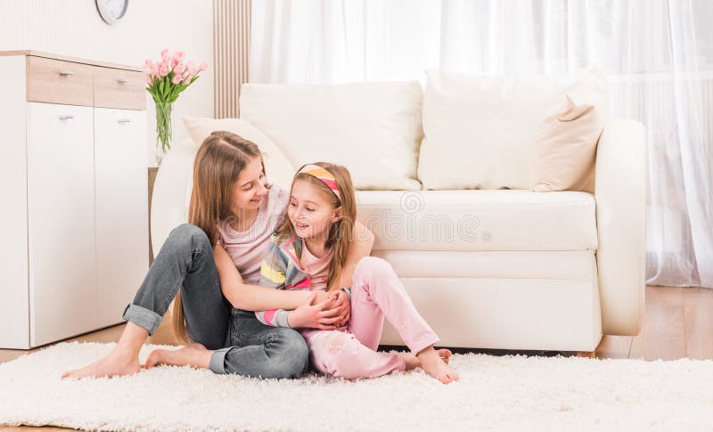 Two Sisters Hugging on the Floor Stock Image - Image of cuddling ...